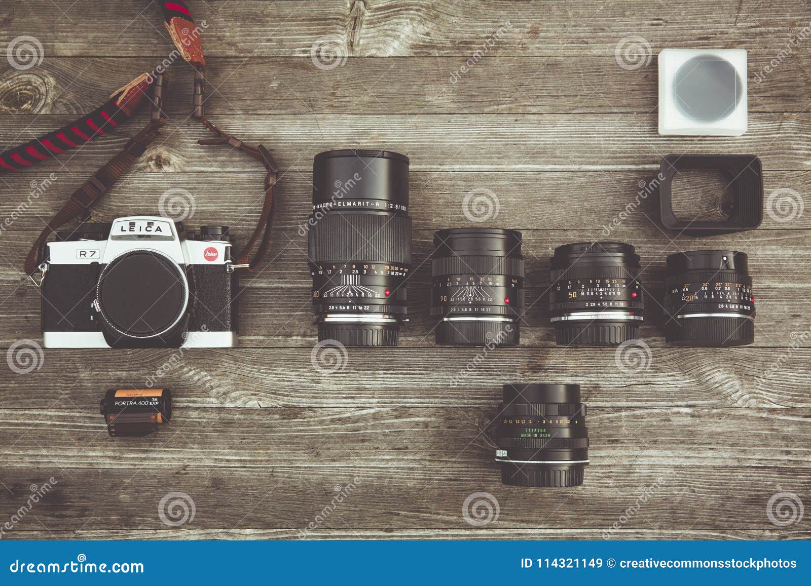 Black And Gray Dslr Camera With Assorted Lenses On Brown Wooden Surface ...