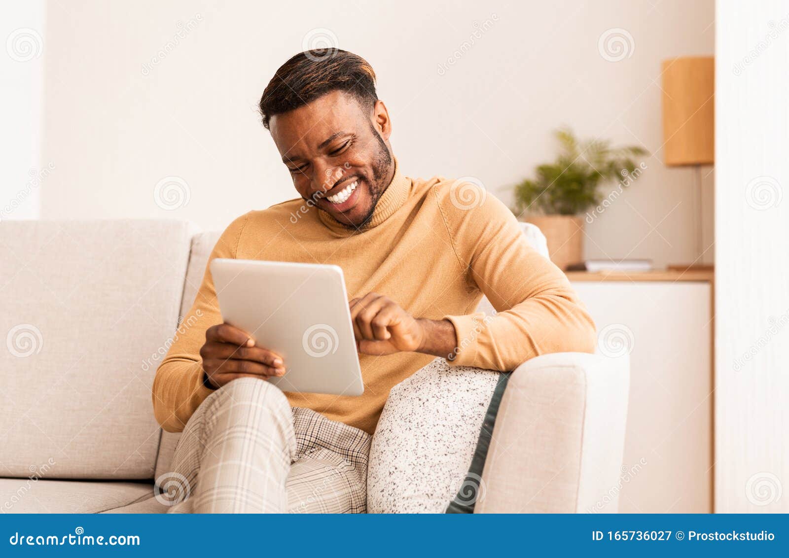 Black Guy Using Tablet Smiling Sitting on Sofa at Home Stock Image ...