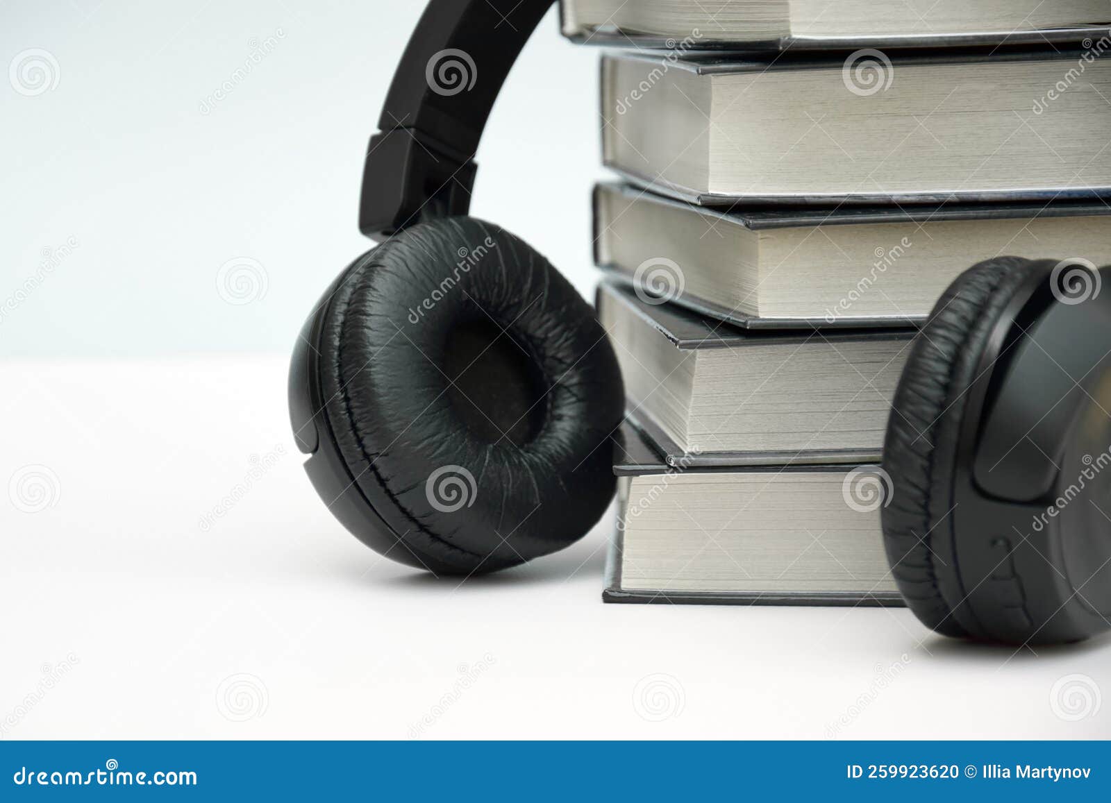 Black Headphones with Stack of Books on Light Background. Stock Photo ...