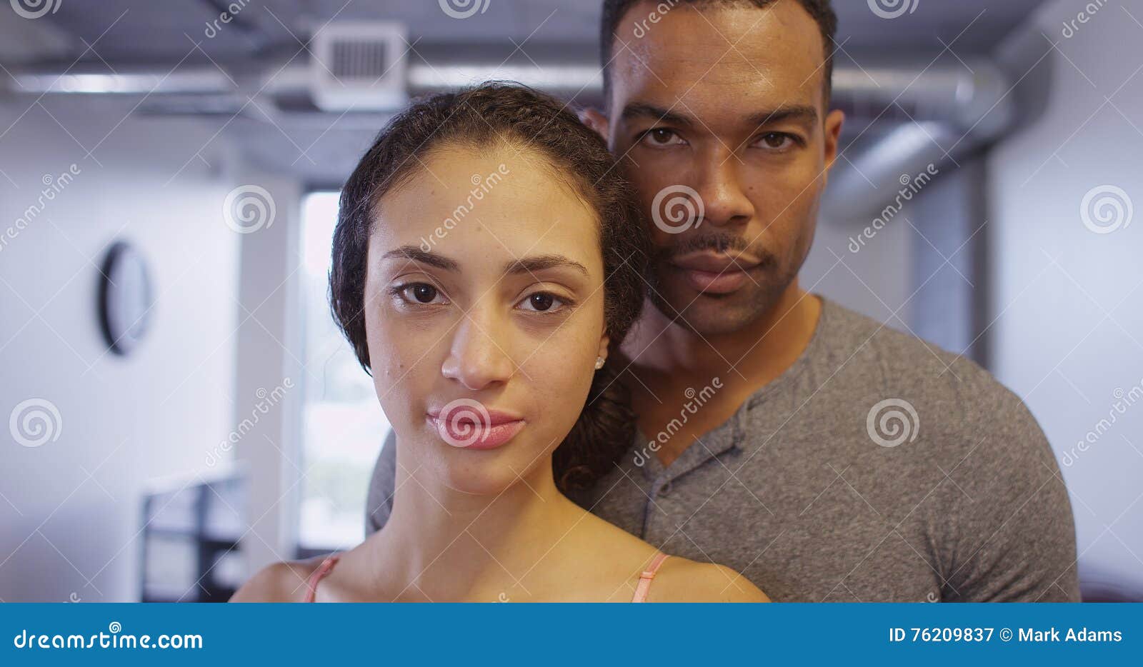 Black and Hispanic Couple Looking at Camera Standing in Apartment Stock ... Black and Hispanic Couple Looking at Camera Standing in Apartment Stock ...