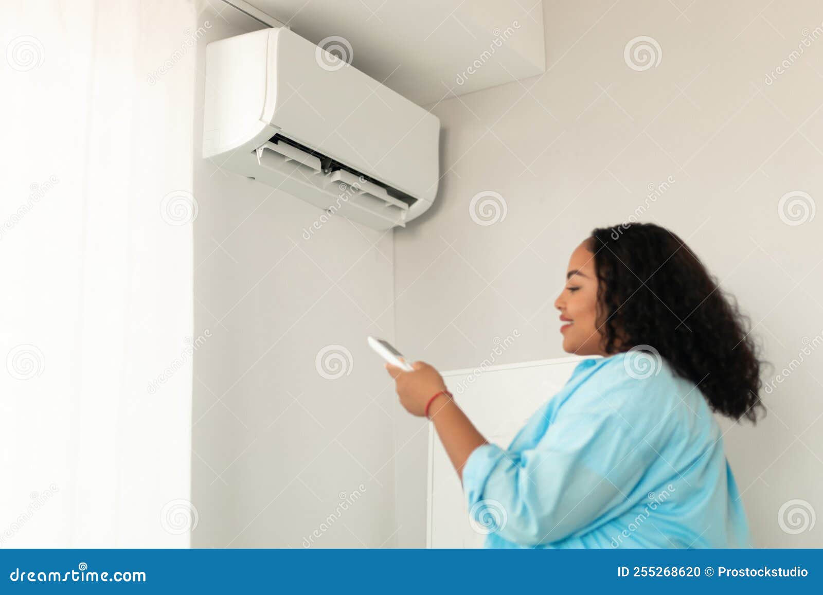 Black Lady Turning on AC with Remote Controller at Home Stock Photo ...