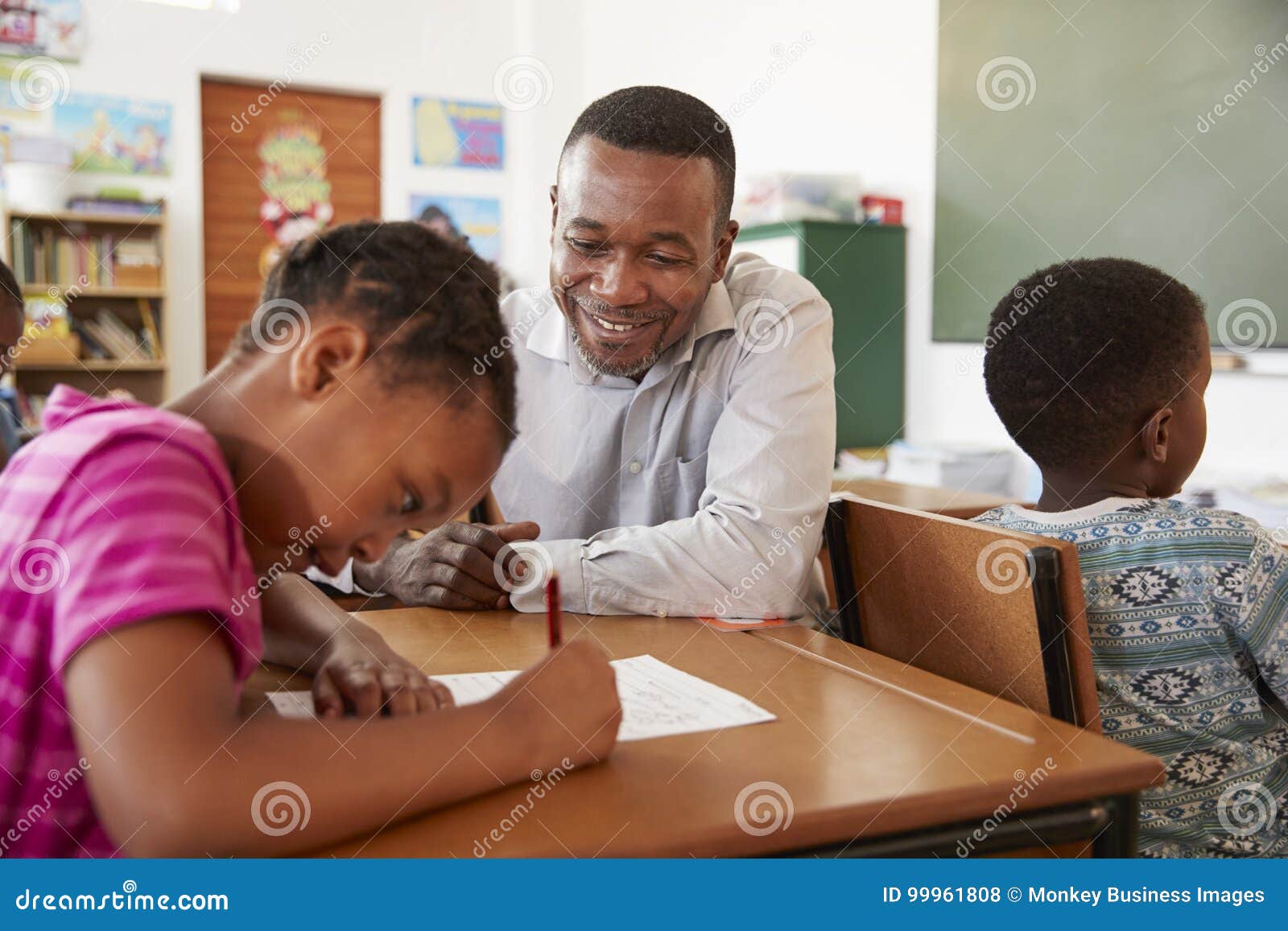 Black Male Teacher Helping Elementary School Girl in Class Stock Photo ... Black Male Teacher Helping Elementary School Girl in Class Stock Photo ...