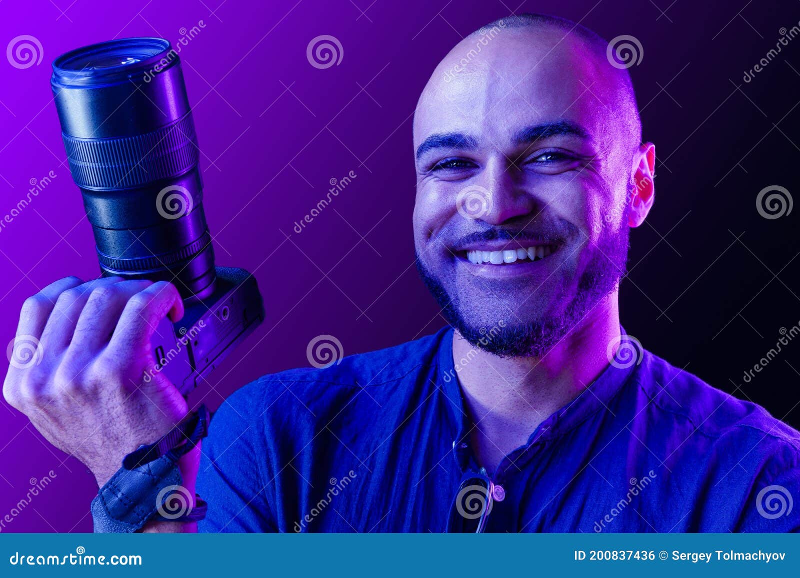 Black Man with Camera Standing Against Purple Background in Neon Light ...