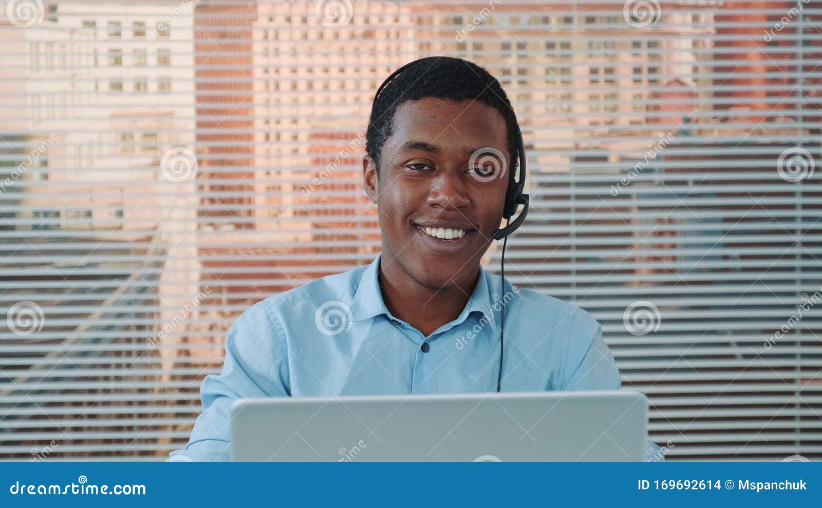 Black Man in Headset Speaking with Somebody and Working on the Computer ...