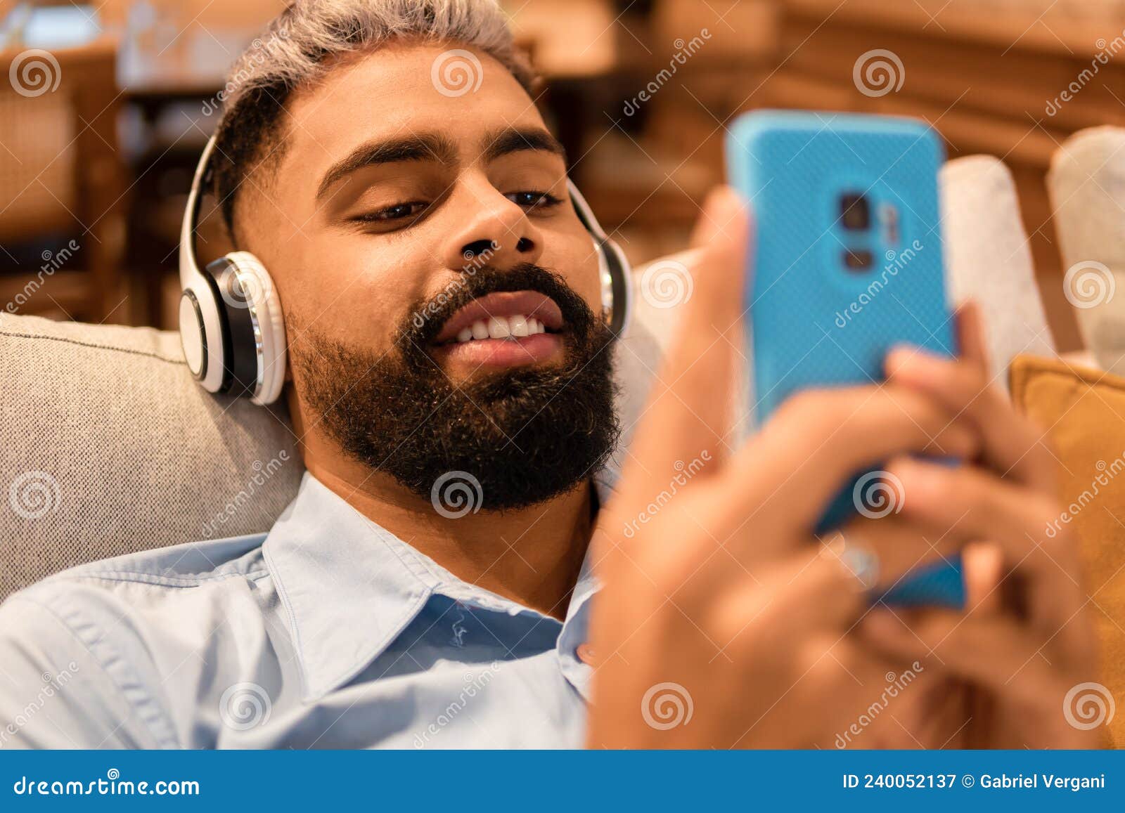 Man Lying and Looking at Mobile Phone and Watching Video in the Couch ...