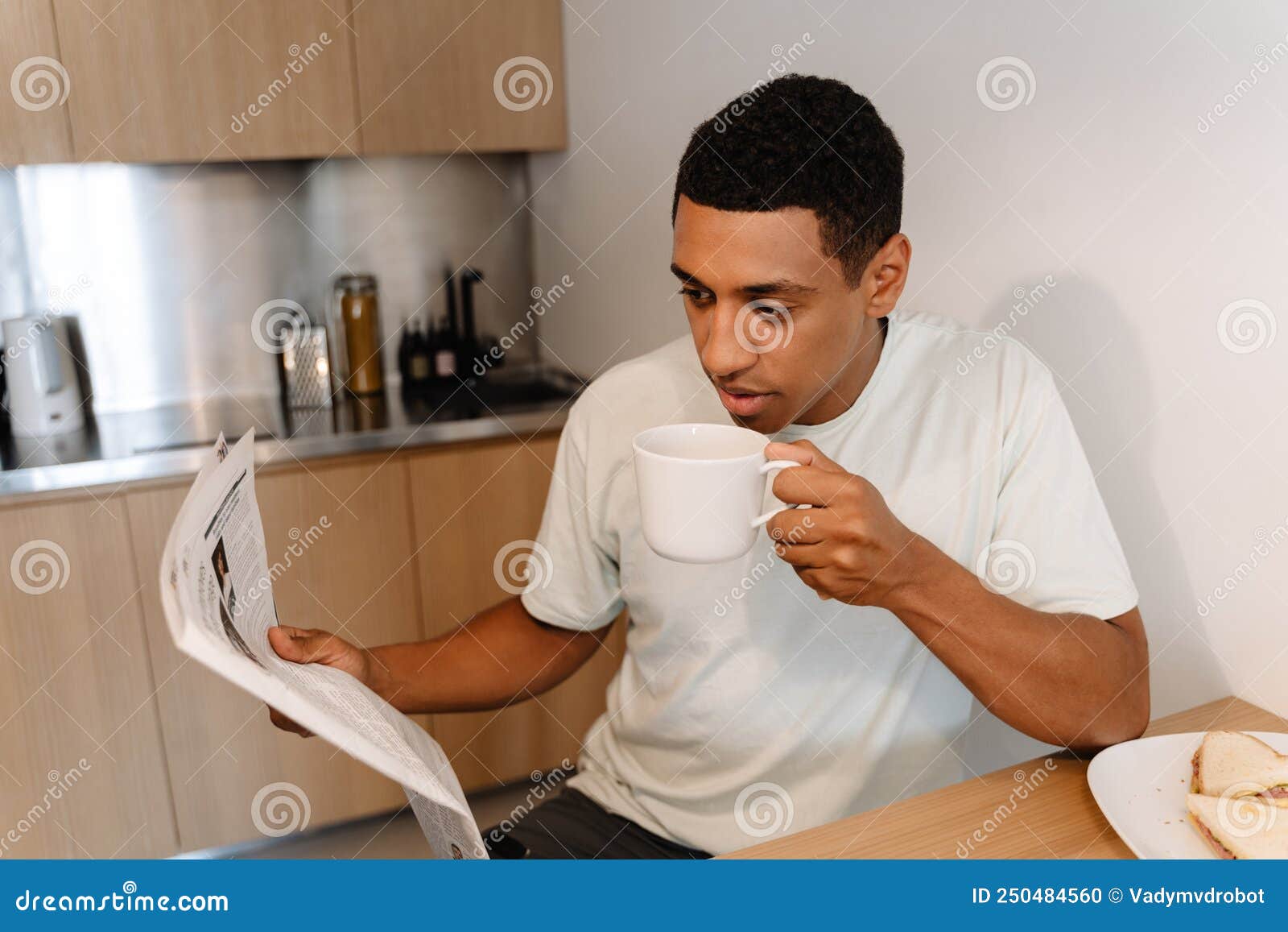 Black Man Reading Newspaper and Drinking Coffee while Having Breakfast ...