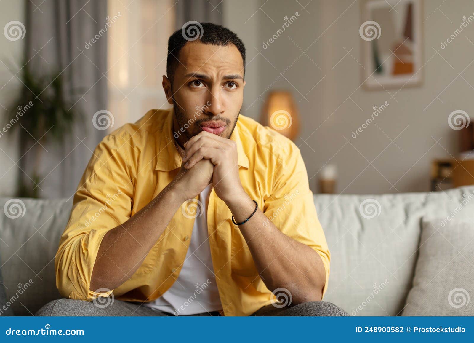Black Man Sitting on Couch with Thoughtful Face Expression, Feeling Sad ...