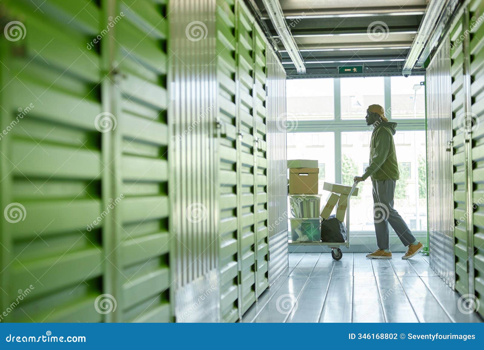 Black Man Transporting Boxes on Cart into Self Storage Unit at ...