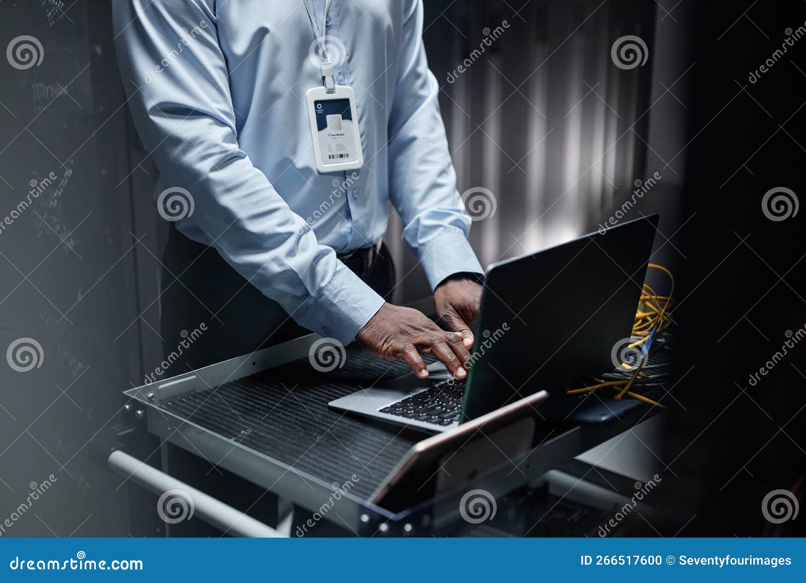 Black Man Typing at Laptop Keyboard while Setting Up Network in Server ...