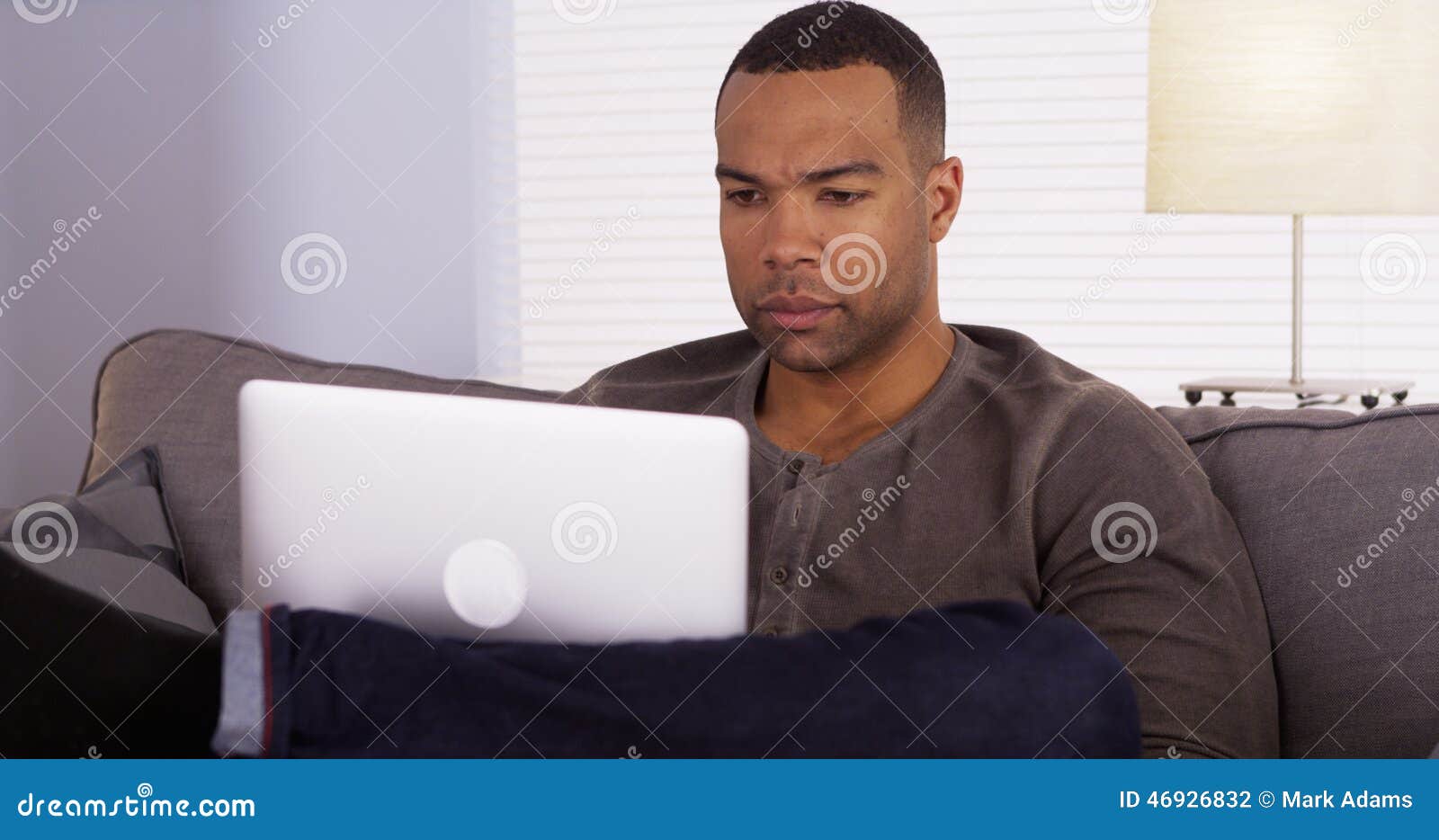 Black Man Using Laptop on Couch Stock Photo - Image of indoors, leisure ...