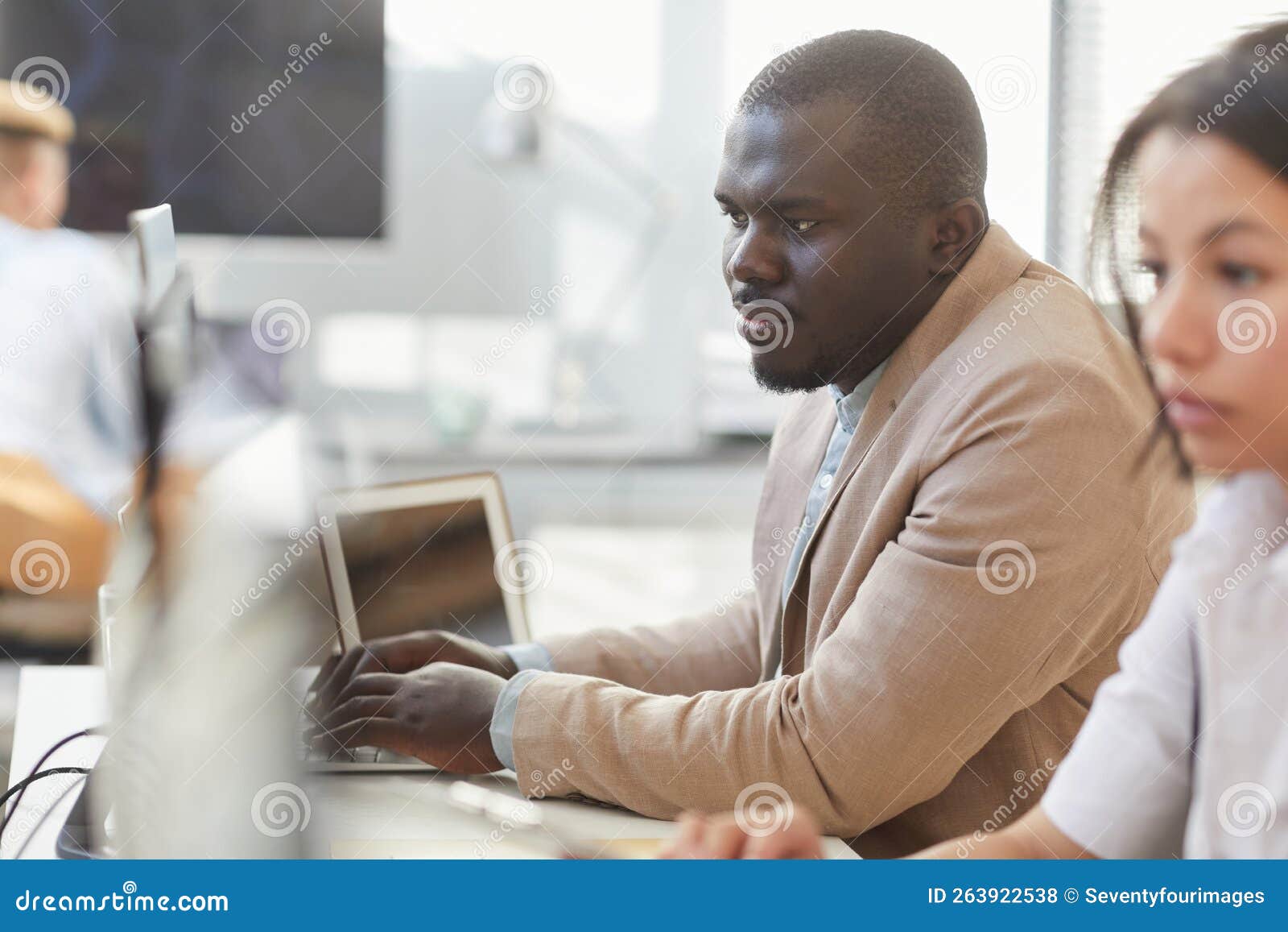 Black Man Using Laptop while Sitting in Row in Customer Support Center ...