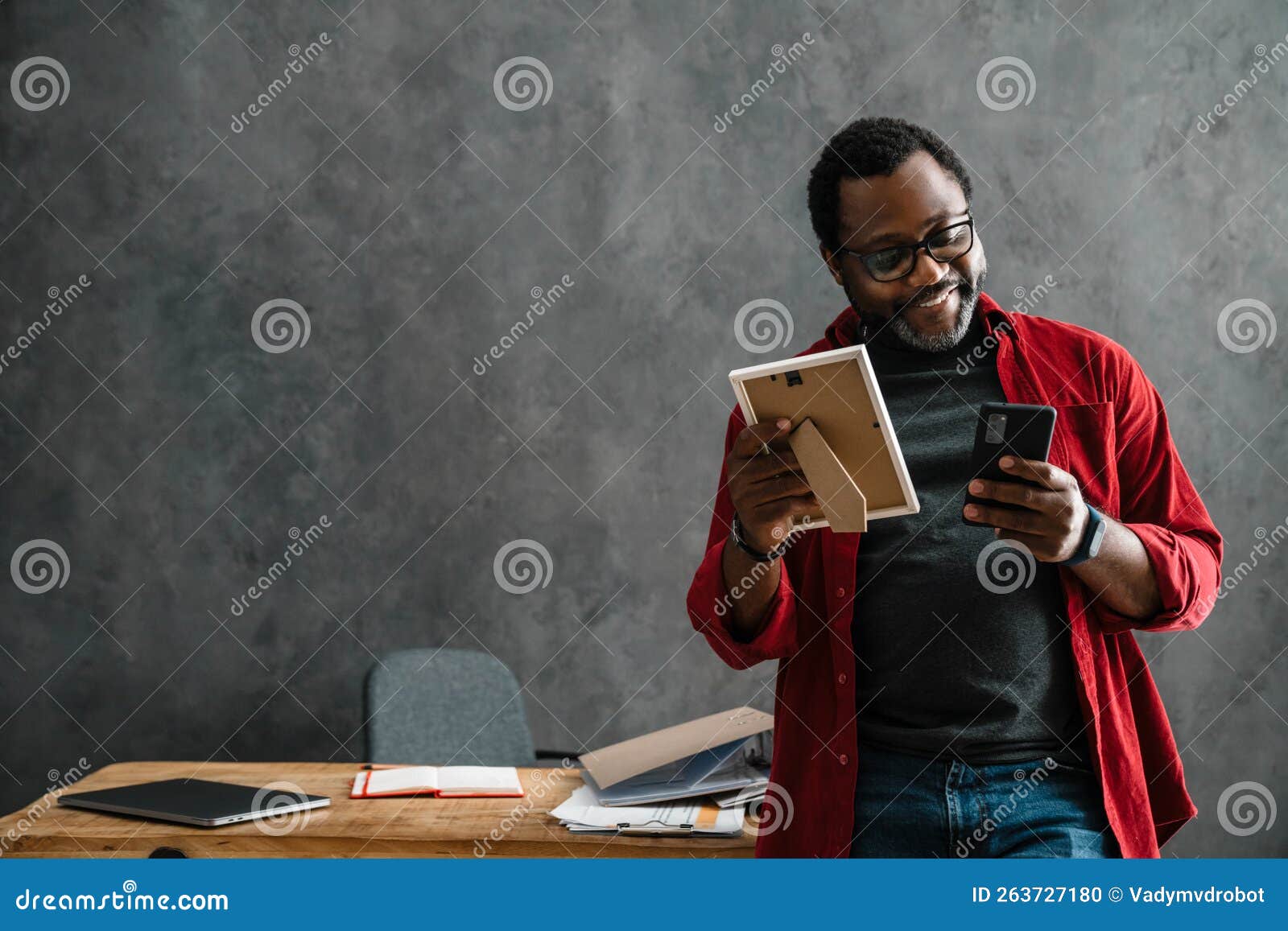Black Man Using Mobile Phone while Working in Office Stock Photo ...