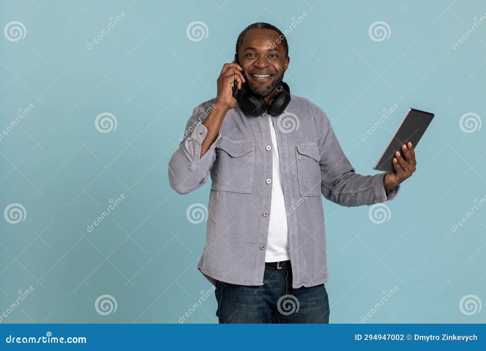 Black Man Using Tablet and Talking Mobile Phone. Stock Photo - Image of ...