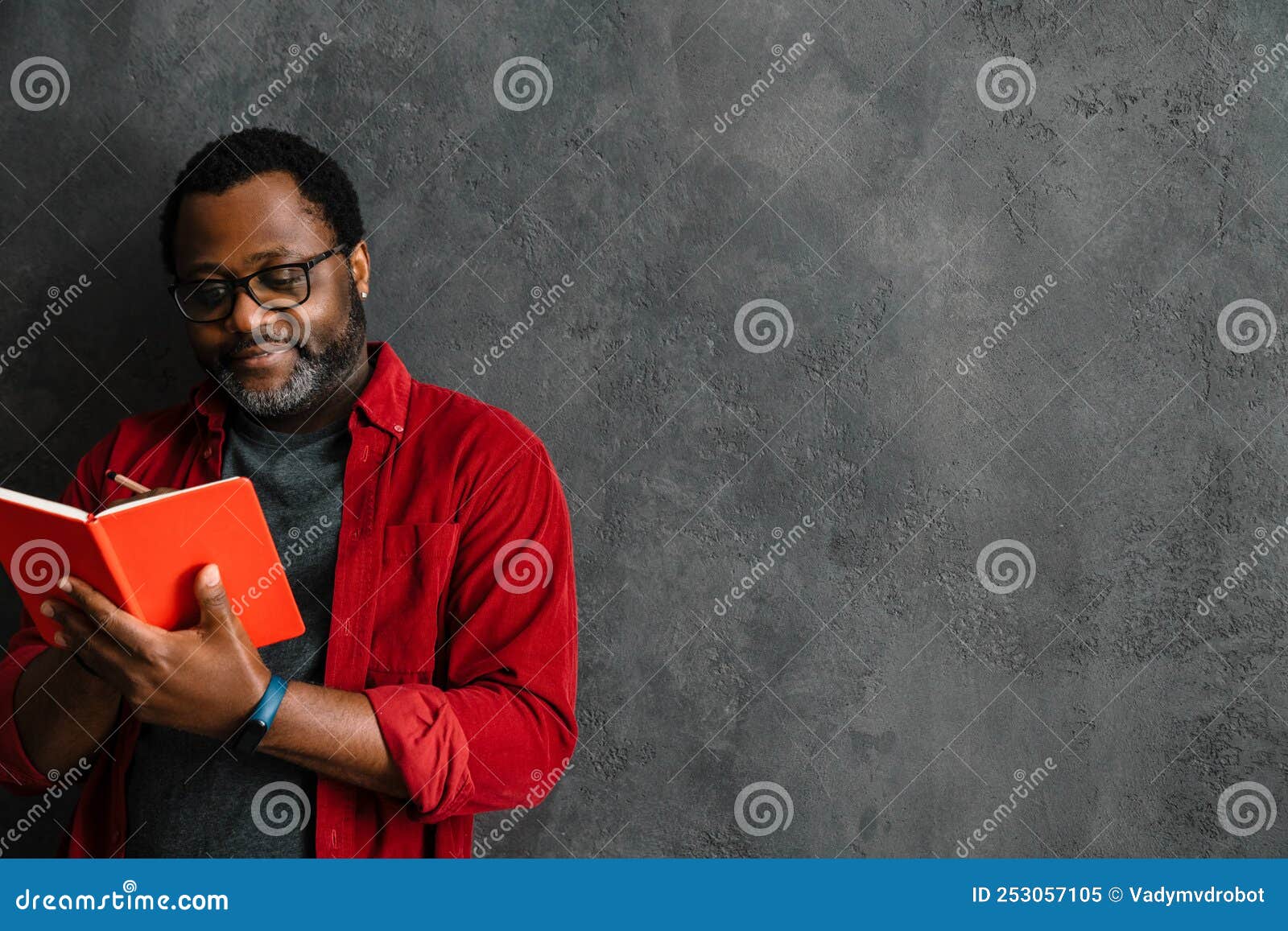 Black Man Writing Down Notes while Leaning on Concrete Wall Stock Image ...