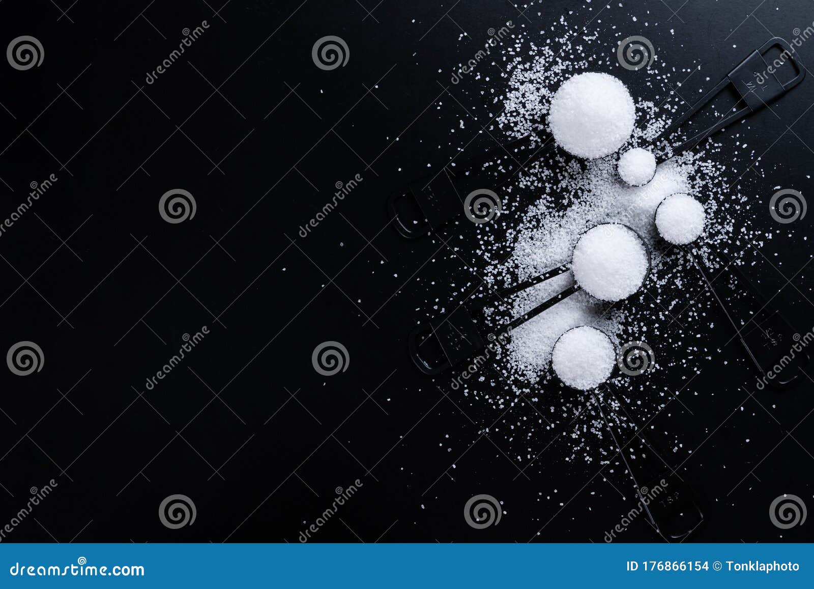 Black Measuring Spoons with Salt on Black Background Stock Photo ...