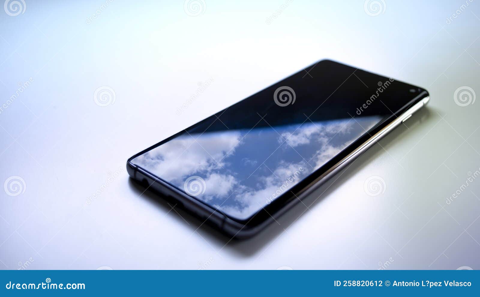 Black Mobile Phone Switched Off on a White Table with the Reflection of ...