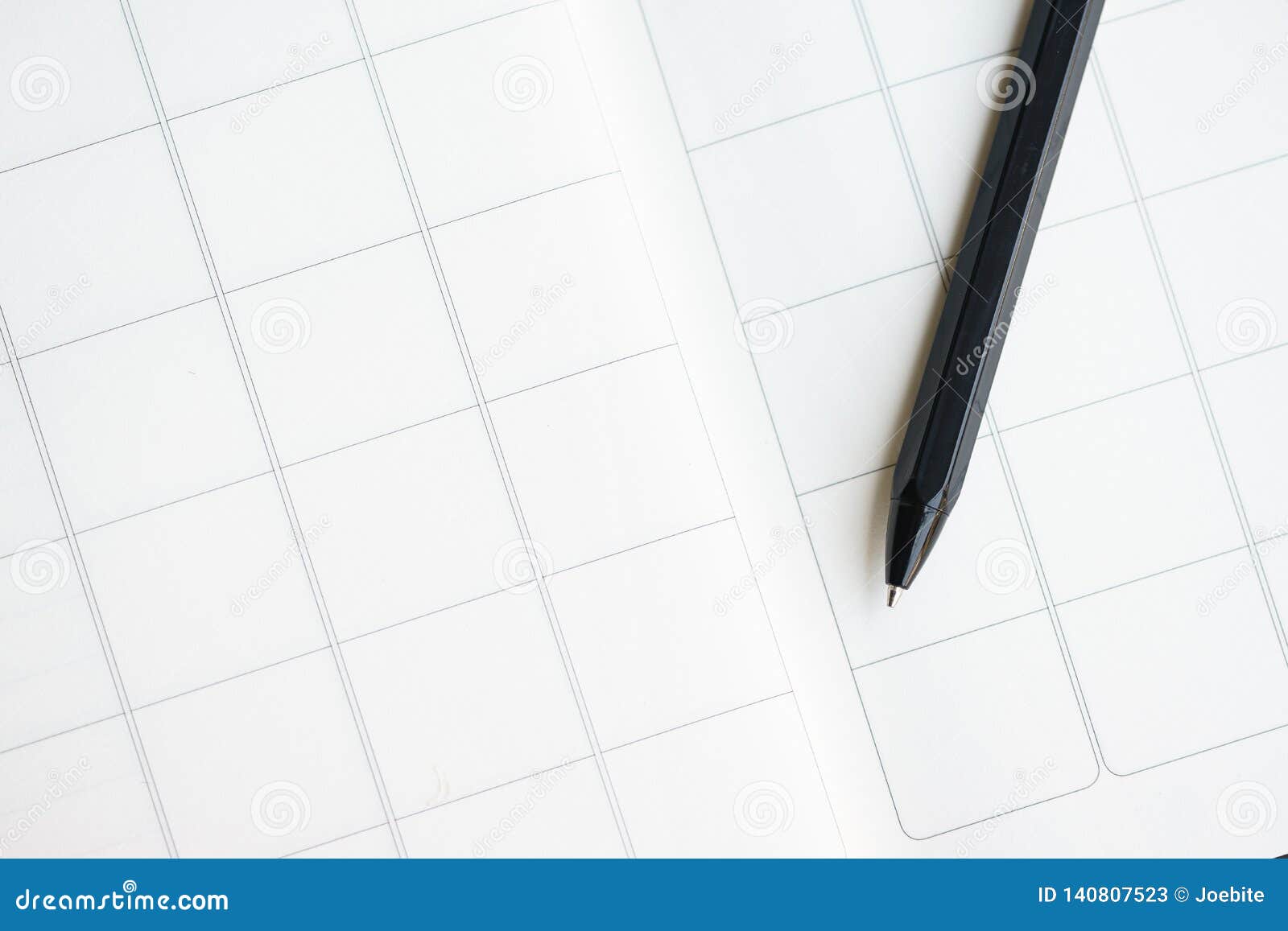 Black Pen Placed on a Notepad with Block Grid Pattern. Stock Image ...