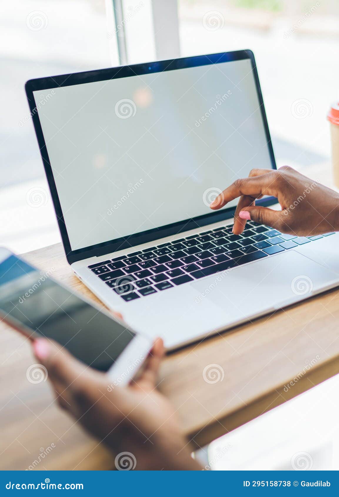 Black Person Typing on Keyboard and Browsing Smartphone in Hand Stock ...