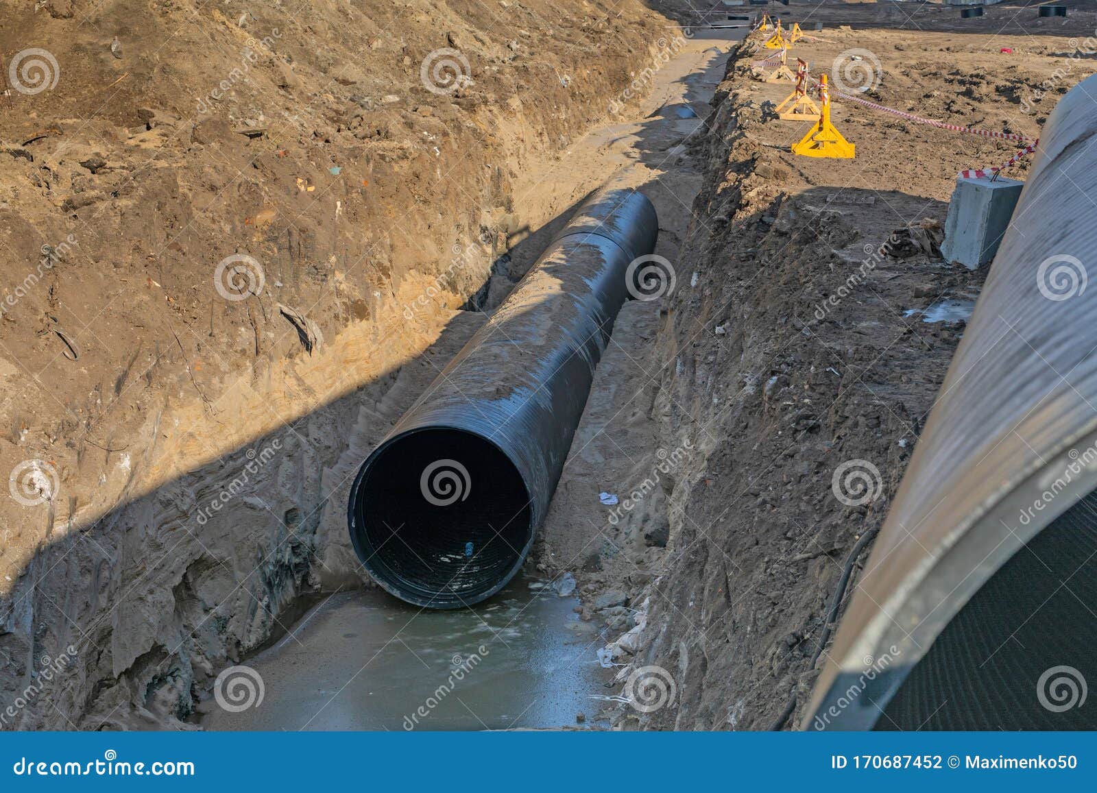 Black Plastic Pipes are in Trench of Ground. Process of Laying of ...
