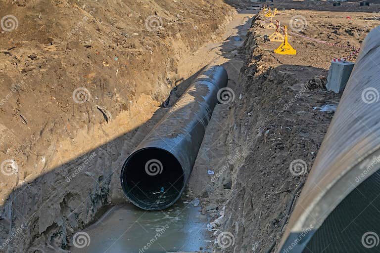 Black Plastic Pipes are in Trench of Ground. Process of Laying of ...