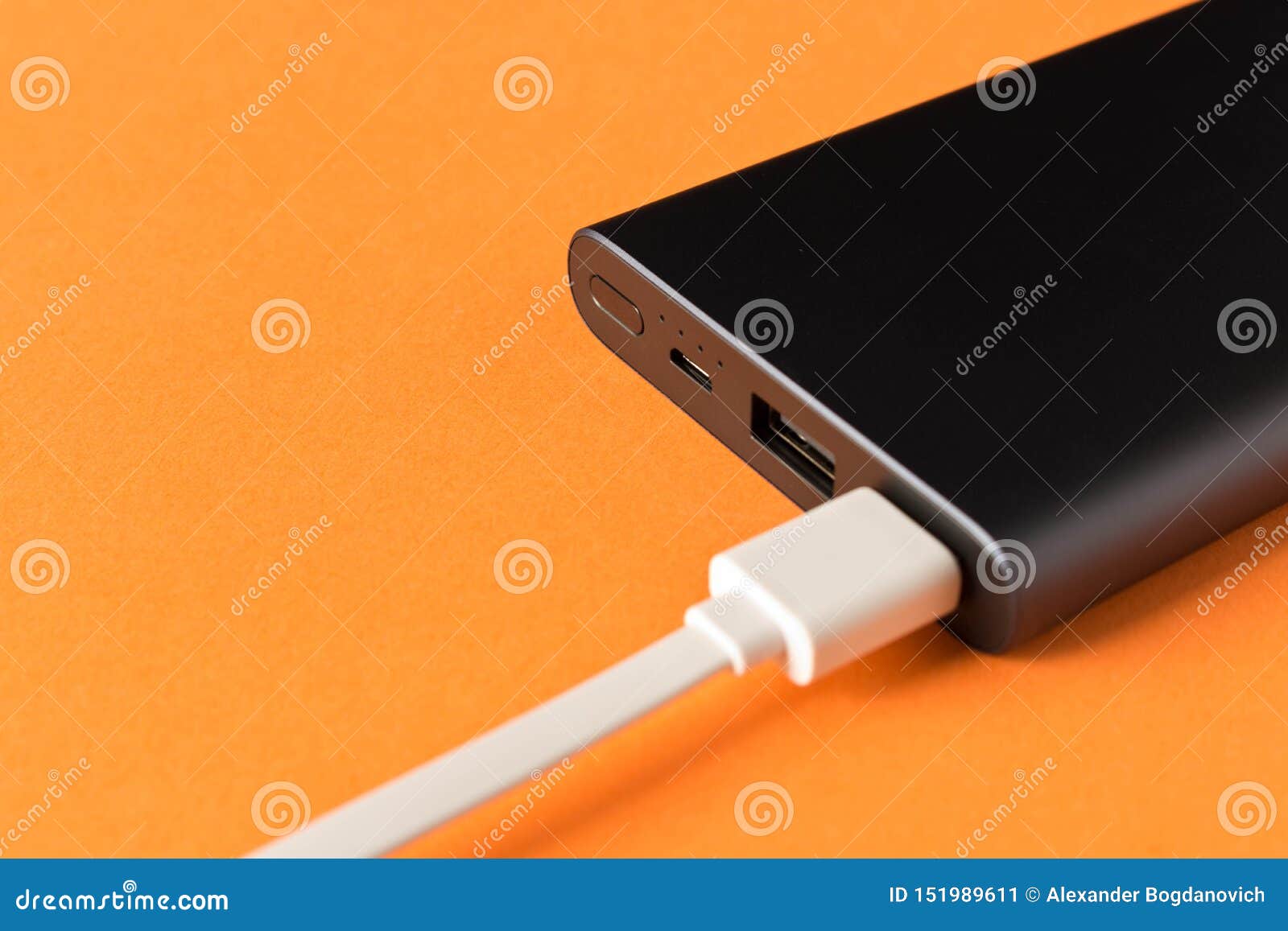 Black Power Bank with Adapter for Charging Mobile Devices on a Orange ...