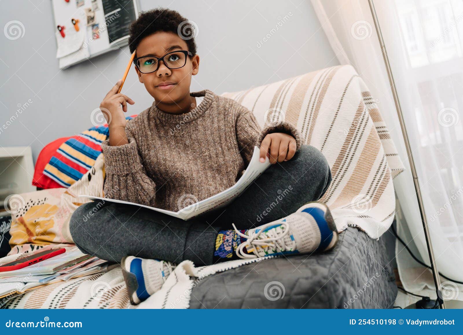 Black Puzzled Boy Doing Homework while Sitting on Sofa Stock Photo ...