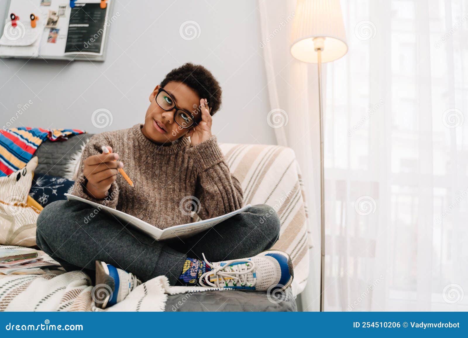 Black Puzzled Boy Doing Homework while Sitting on Sofa Stock Photo ...