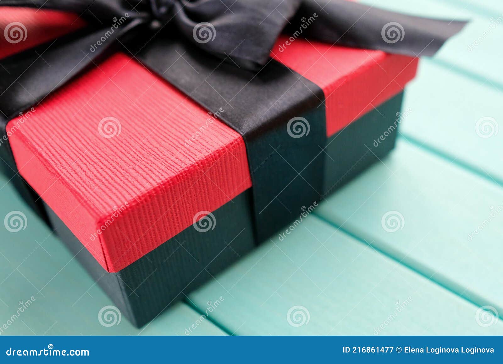 Black and Red Box with a Bow on a Blue Background Stock Image - Image ...
