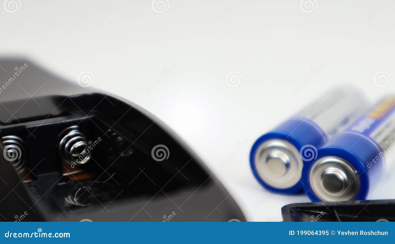 Black Remote Control with Blue AAA Batteries on a White Background ...