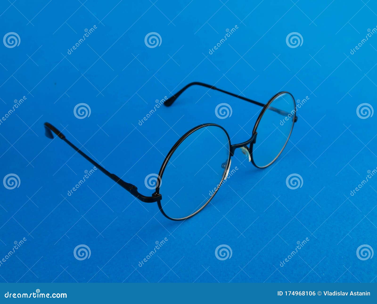 Black Round Glasses Against a Blue Background Standing Sideways Stock ...
