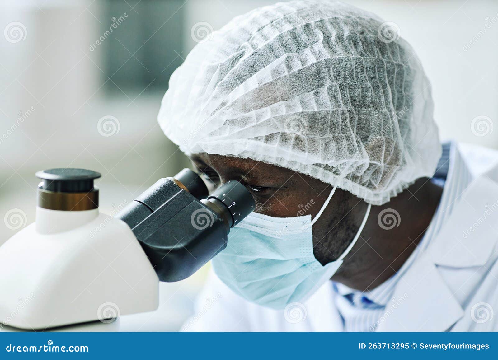 Black Scientist Looking in Microscope Working on Research in Laboratory ...