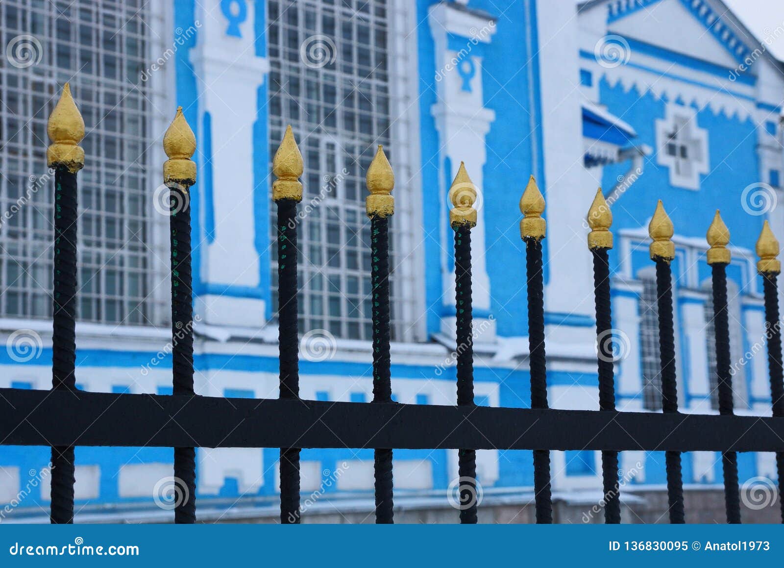 Black Sharp Iron Bars of the Fence Against a Blue White Wall with ...