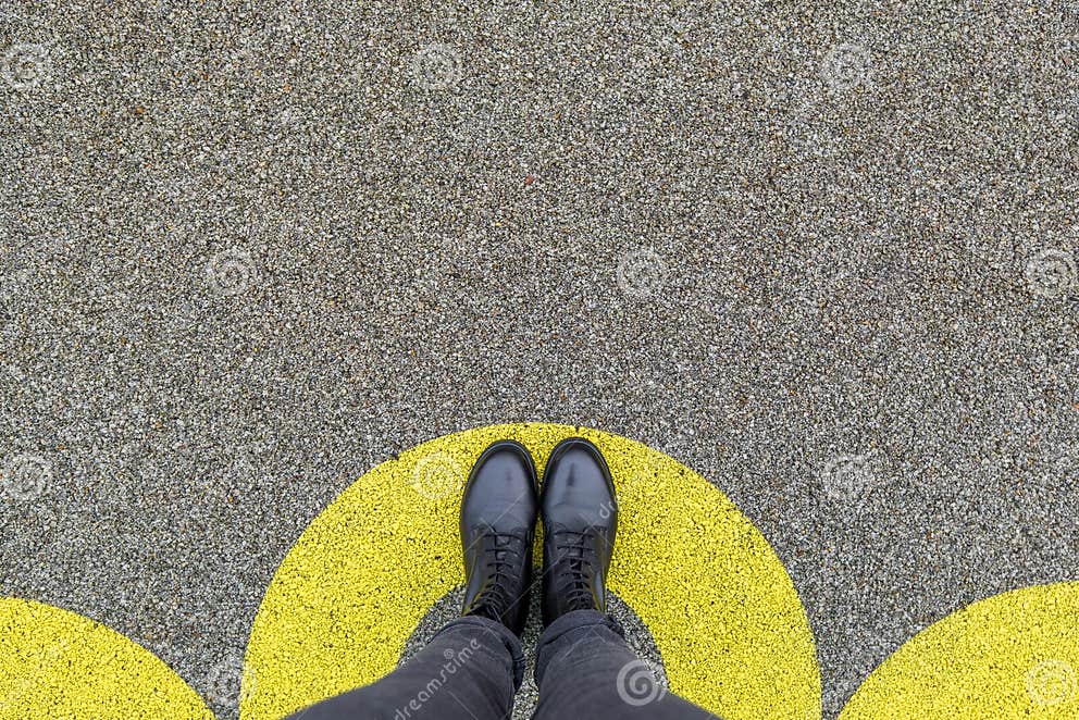 Black Shoes Standing In Yellow Circle On The Asphalt Concrete Floor