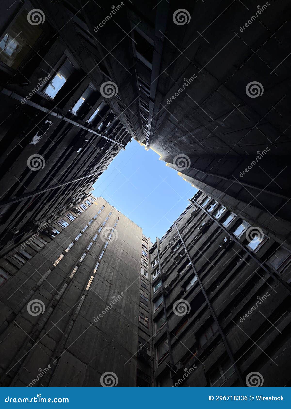 A Black Square in between Some Tall Building with Windows in it Stock ...