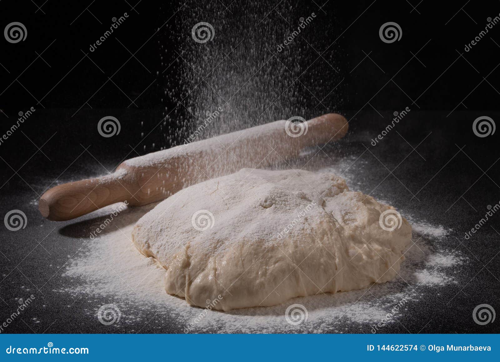 On the Black Table a Pile of Dough with a Rolling Pin on Top of the ...