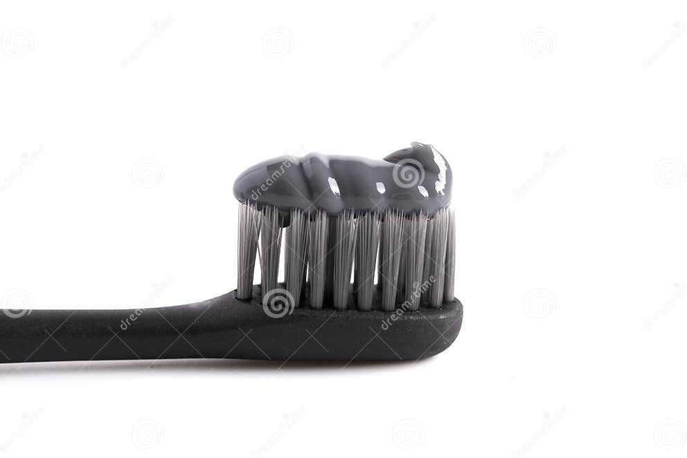 A Black Toothbrush with Black Activated Charcoal Toothpaste on a White ...
