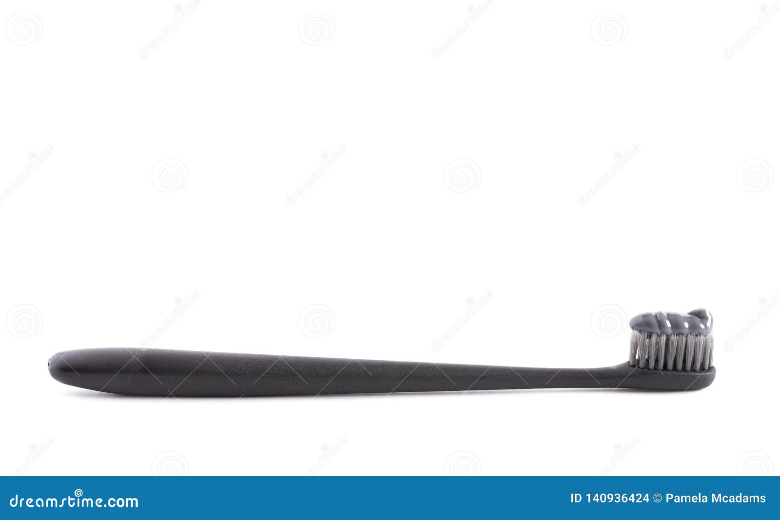 A Black Toothbrush with Black Activated Charcoal Toothpaste on a White ...