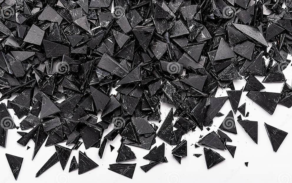 Black Triangular Fragments Scattered on a White Surface, Showcasing ...