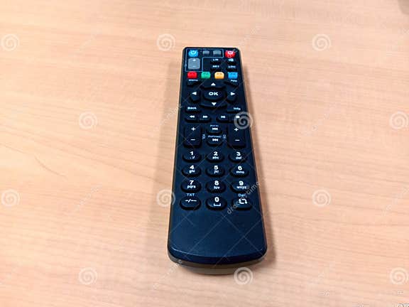 A Black TV Remote on a Brown Table Stock Image - Image of office ...