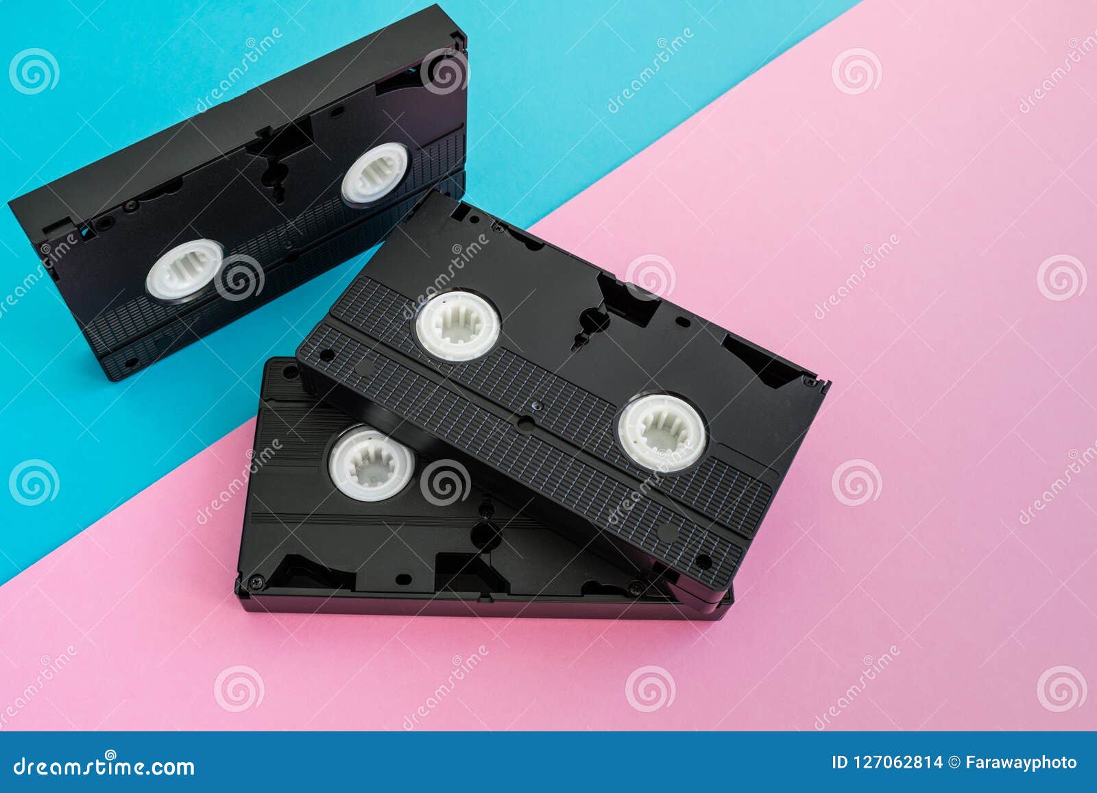 3 Black VHS Video Tapes on a Pink and Blue Background Stock Photo ...