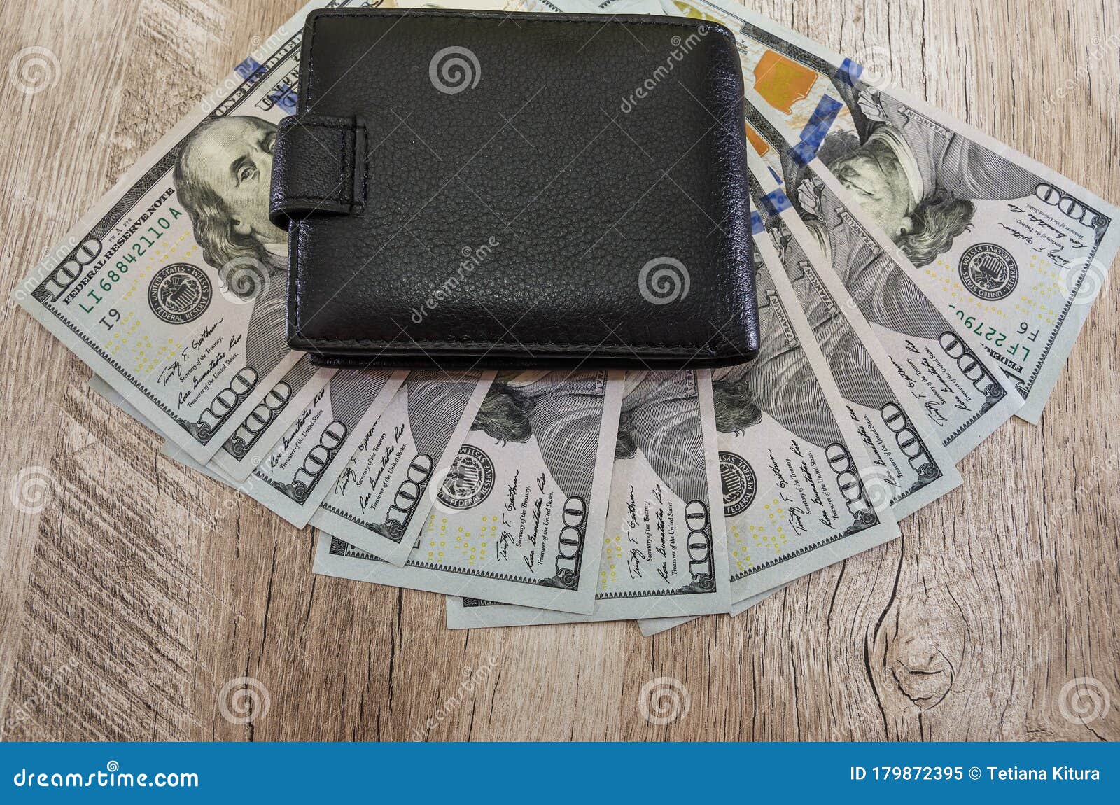 Black Wallet on Dollars on a Wooden Background. View from Above. Stock ...