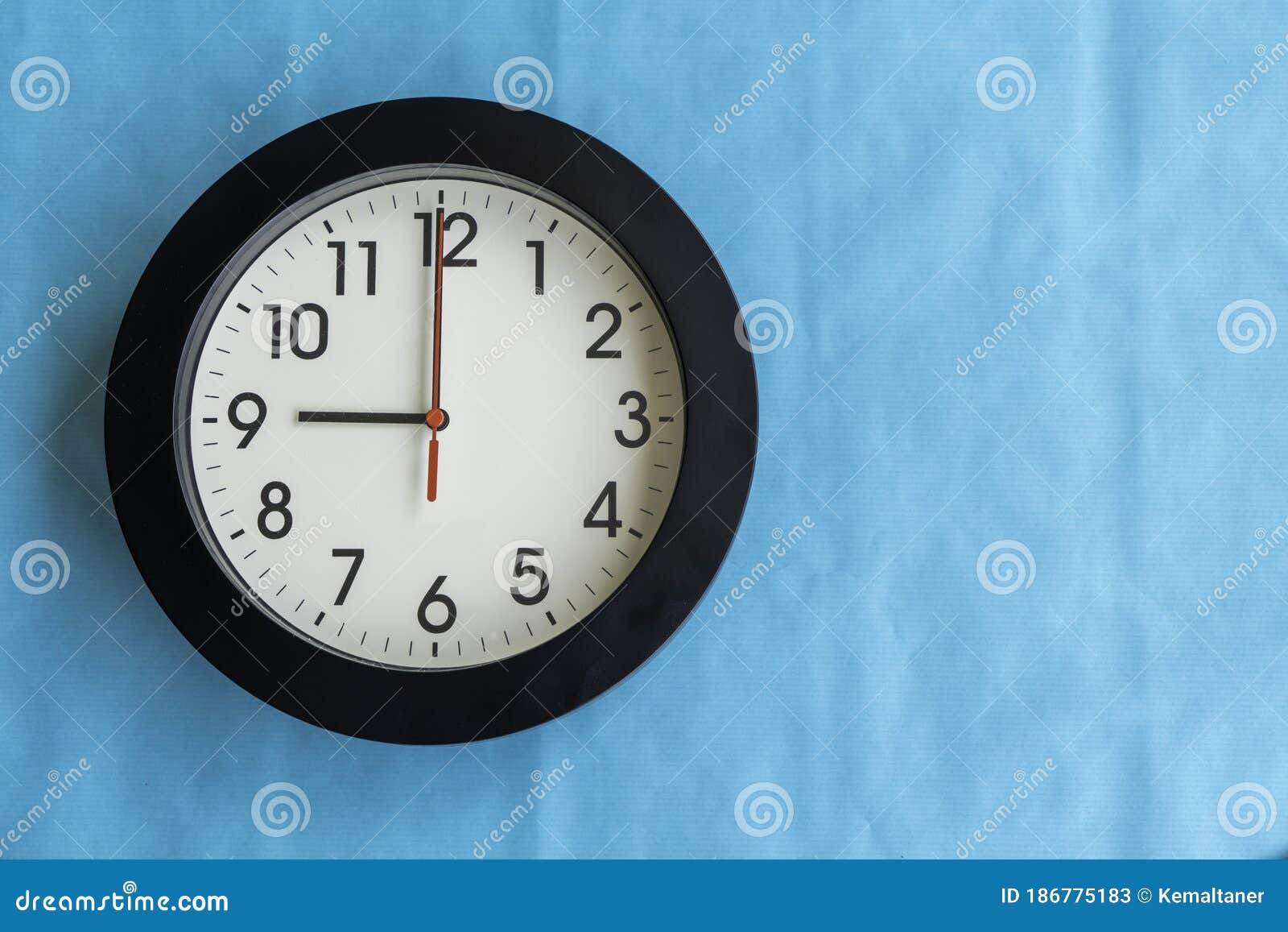 A Black and White Clock on a Blue Wall Stock Image - Image of metallic ...