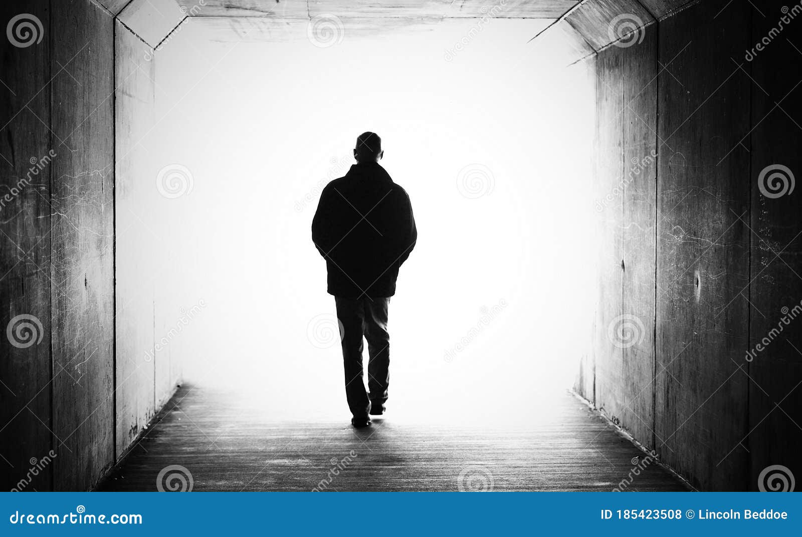 Black and White Image of a Man Hands in Pockets Walking Away in a Dark ... Black and White Image of a Man Hands in Pockets Walking Away in a Dark ...
