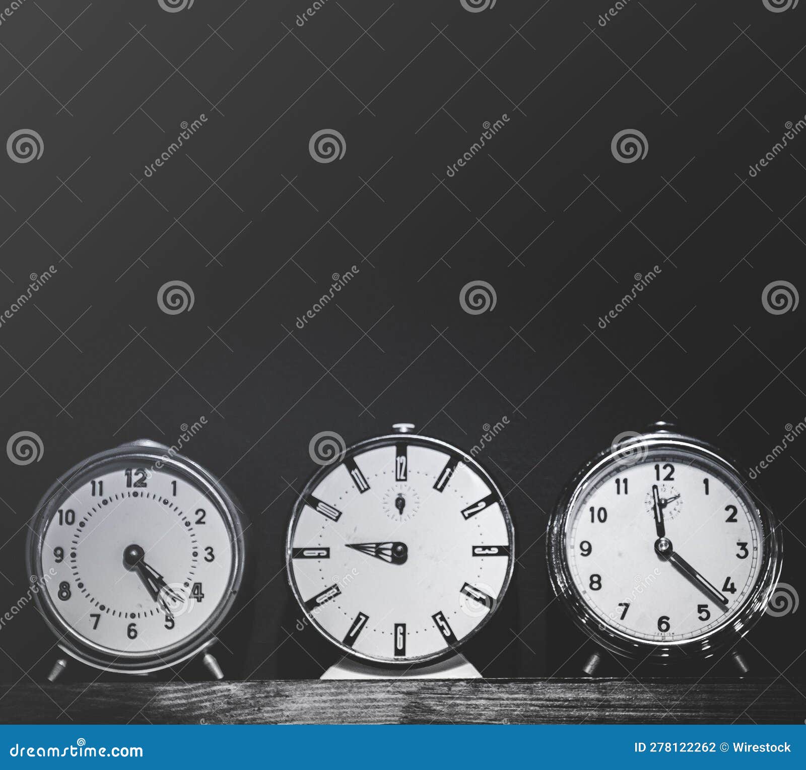 A Grayscale Shot of Three Old Fashioned Circular Analogue Clocks on a ...