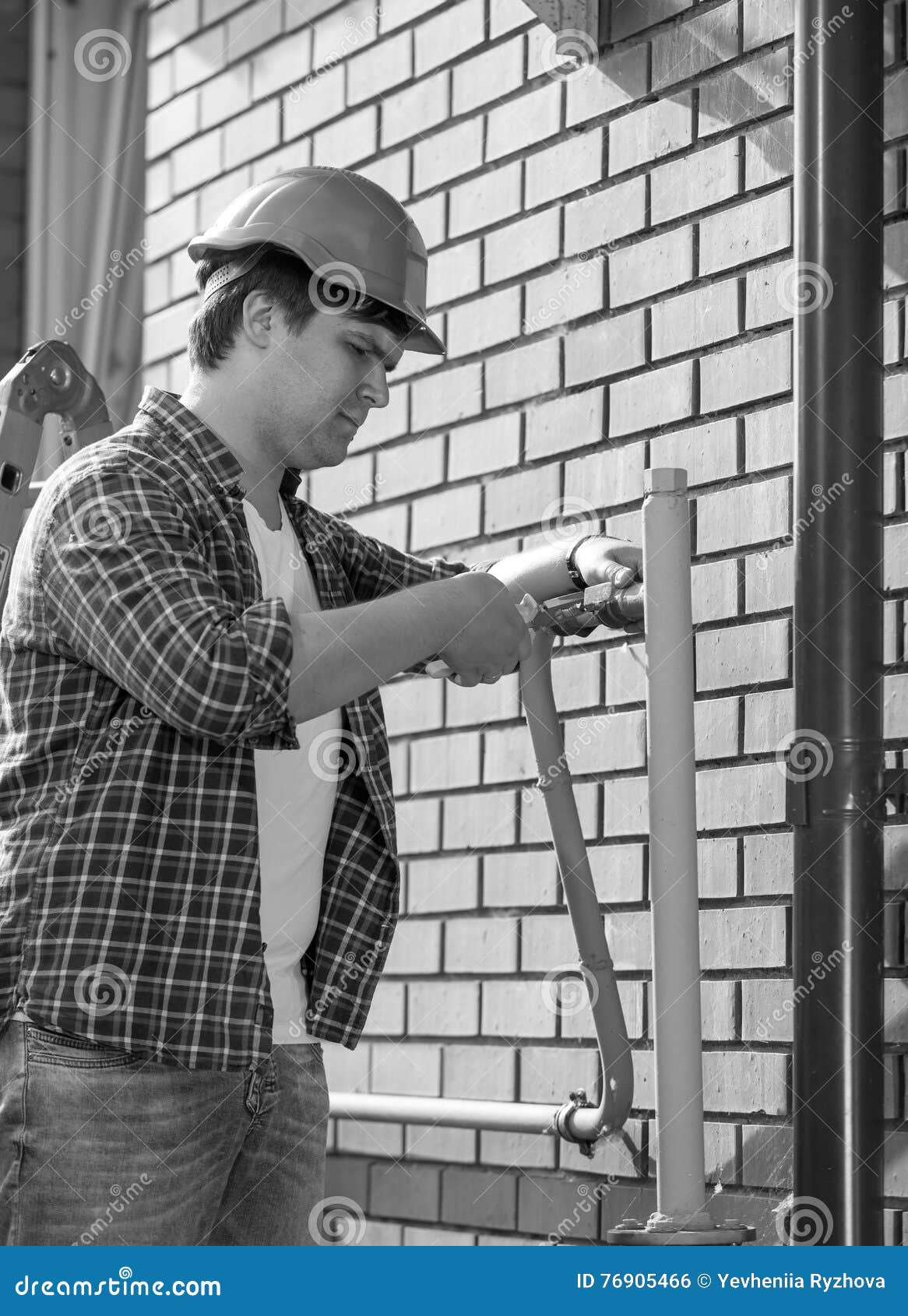 Black and White Portrait of Plumber Assembling Pipes on Outer Wa Stock ...