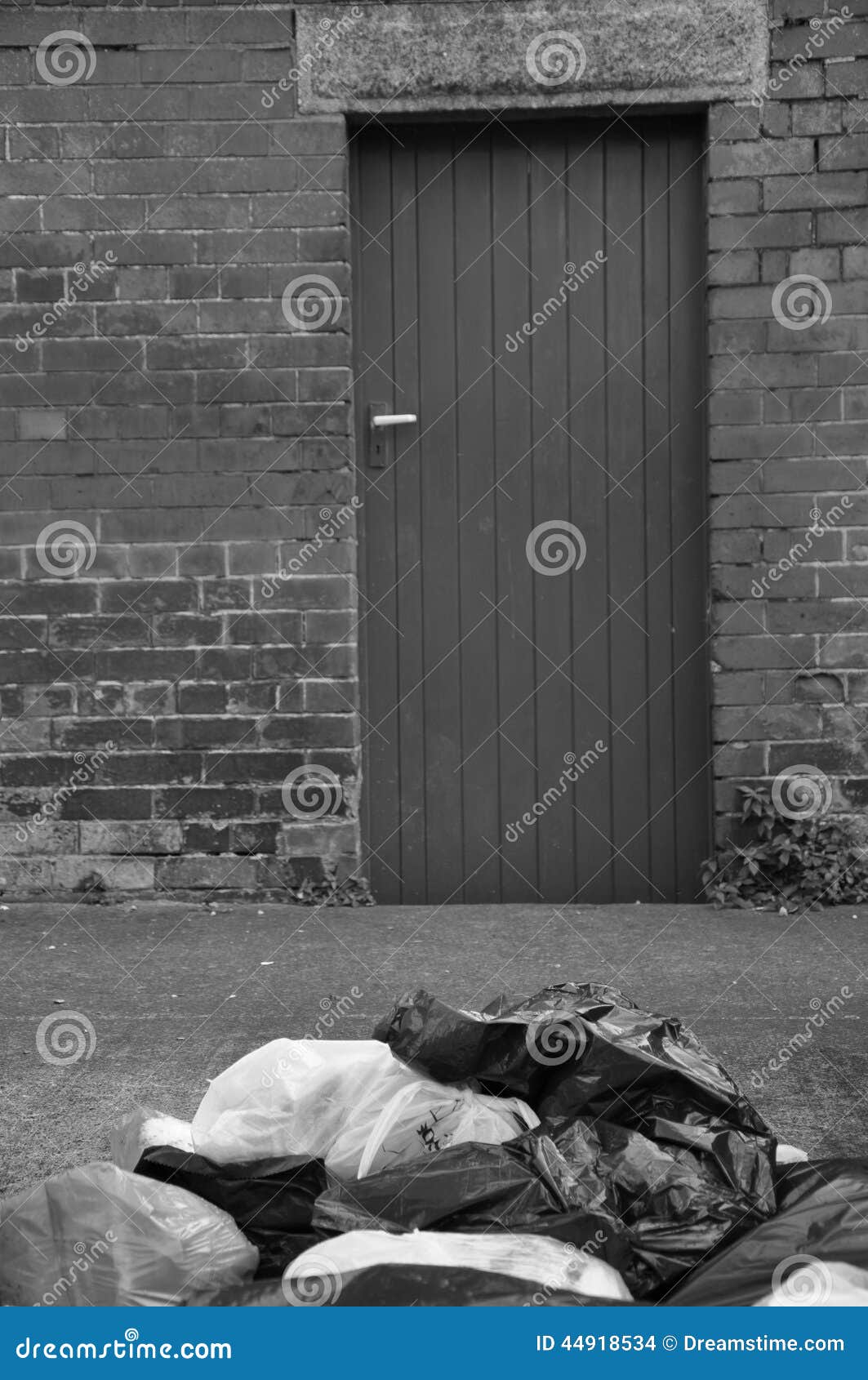 Black and White Rubbish Dumped Against Brick Wall Stock Photo - Image ...