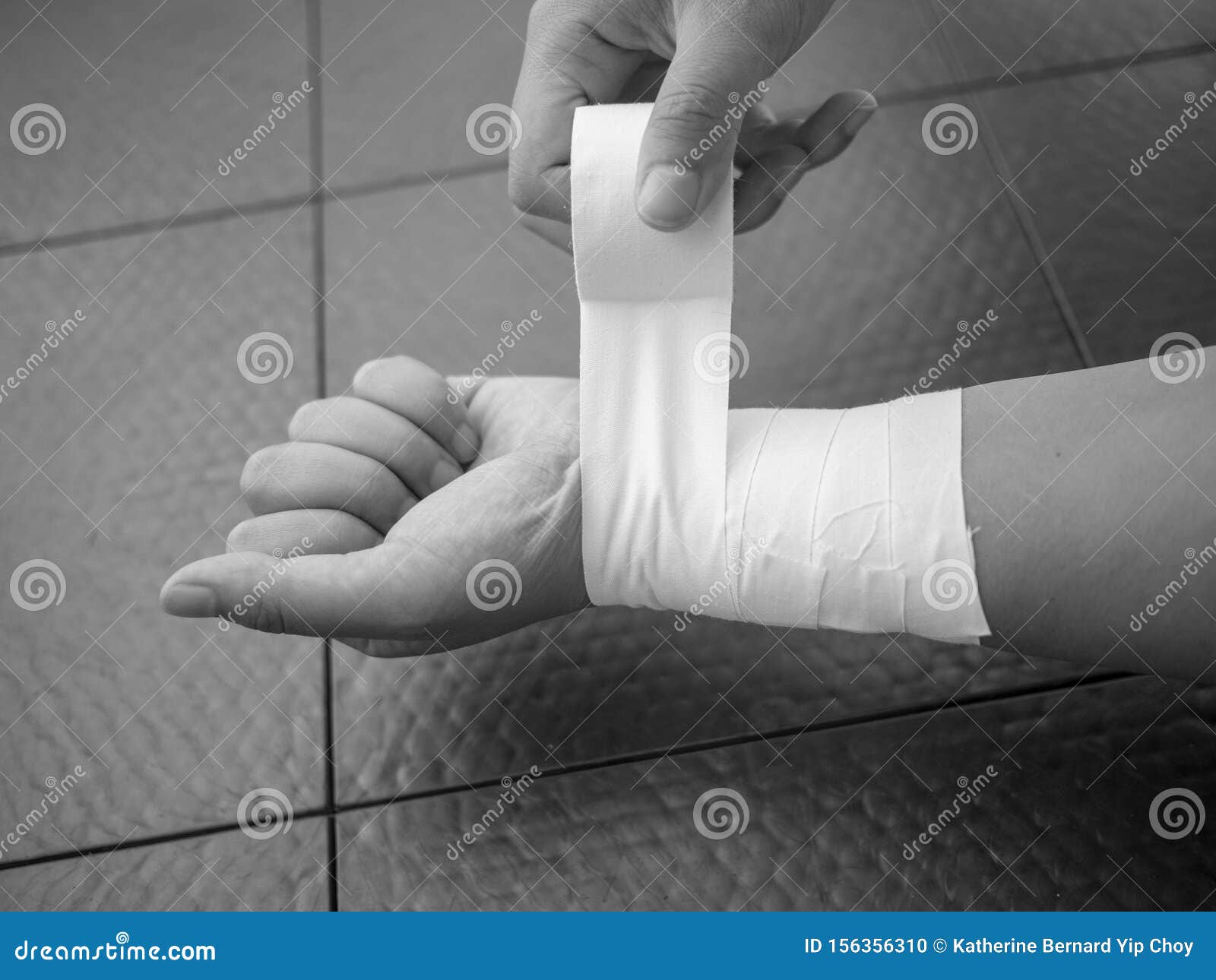 Black and White Version of Athlete Taping Her Wrist for Injury and ...