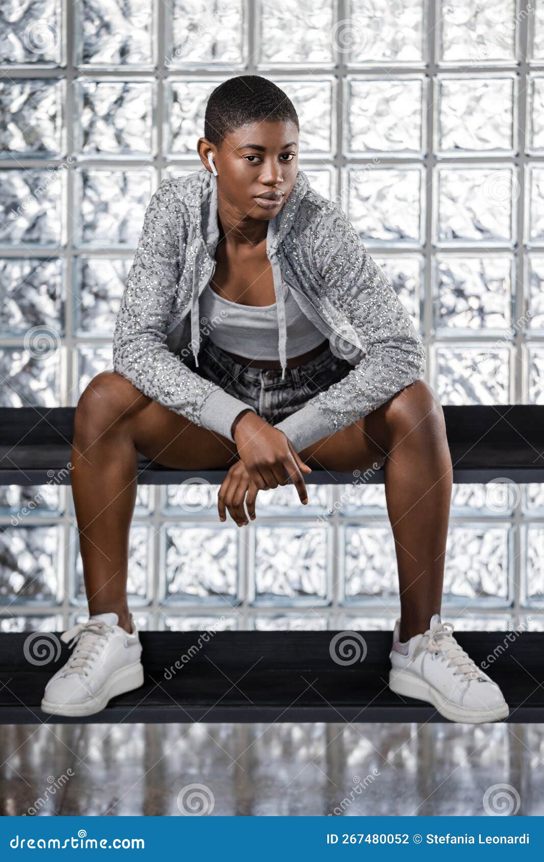 Black Woman with Elbows Leaning on Knees Sitting on a Bench Stock Photo ...