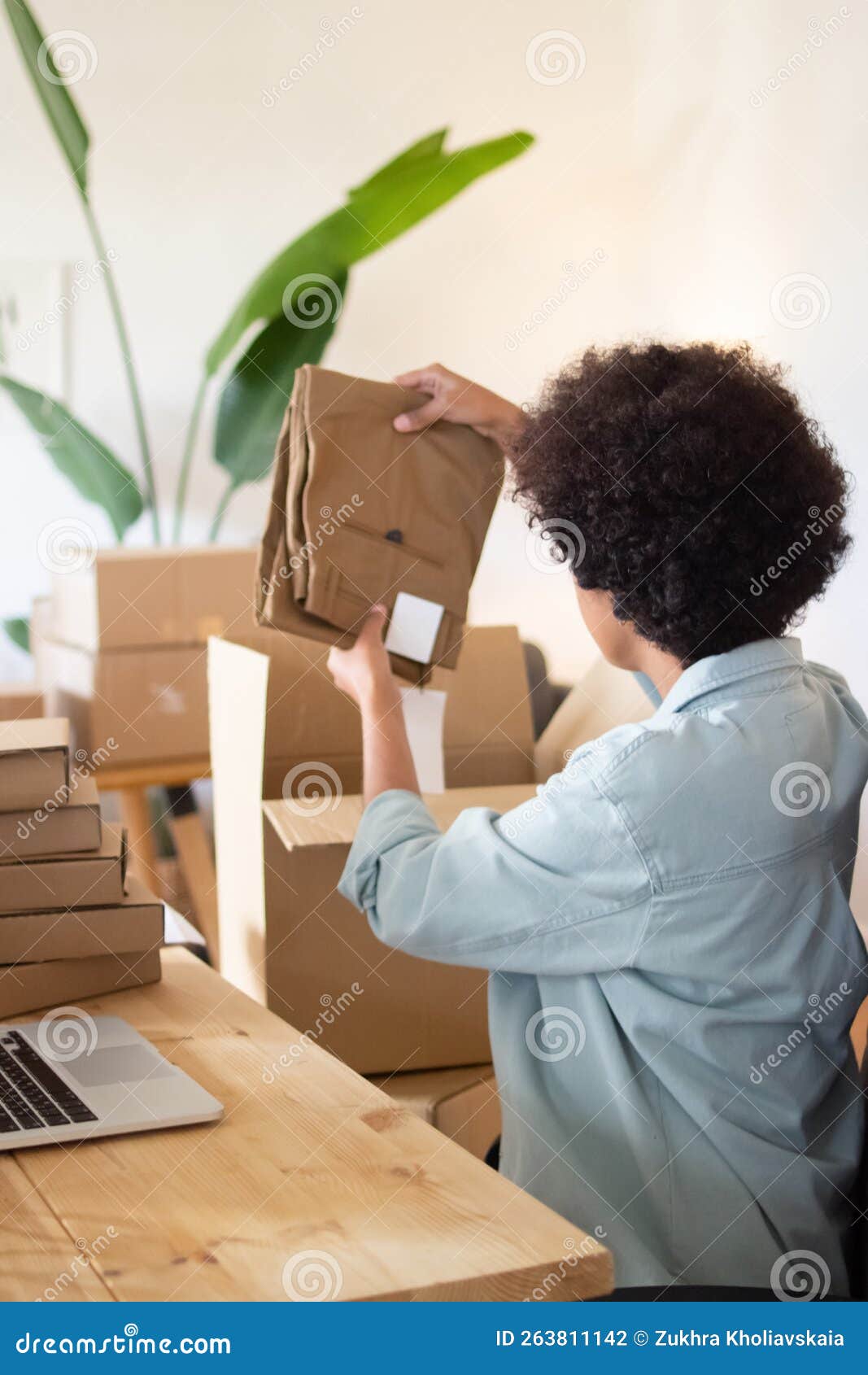 Black Woman Packing Pants into Box Stock Photo - Image of checking ...