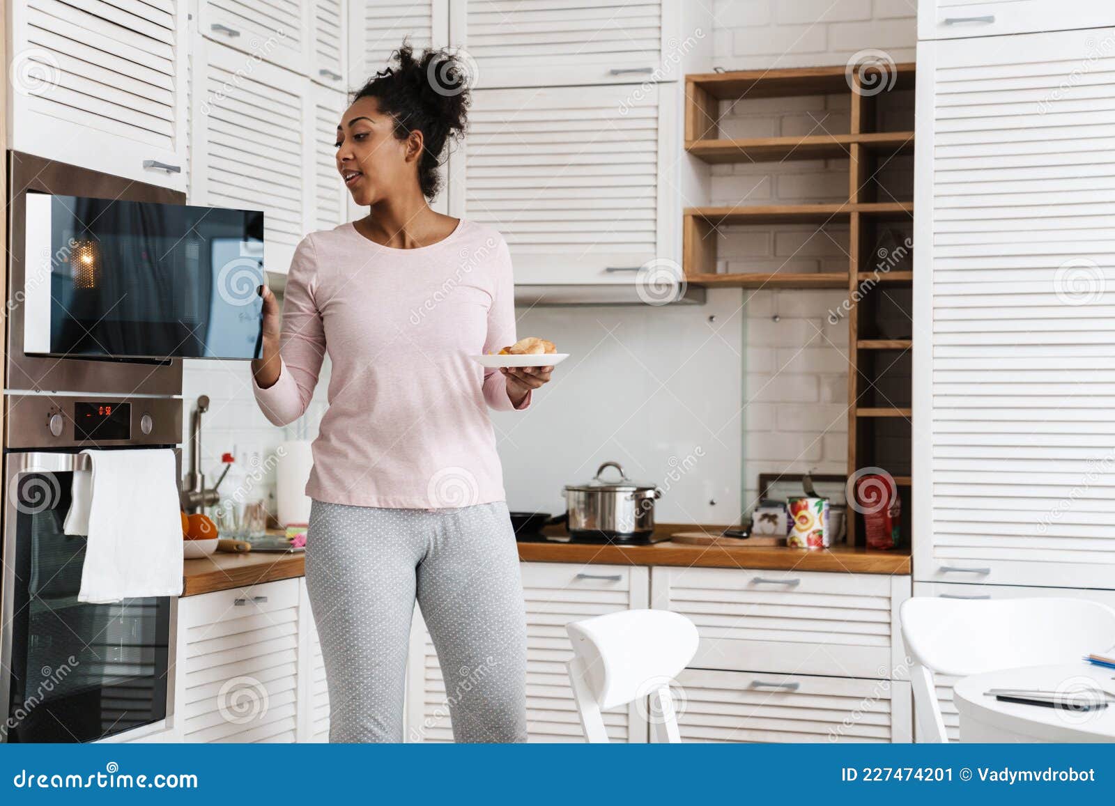 Black Woman Using Microwave while Preparing Her Breakfast Stock Image ...